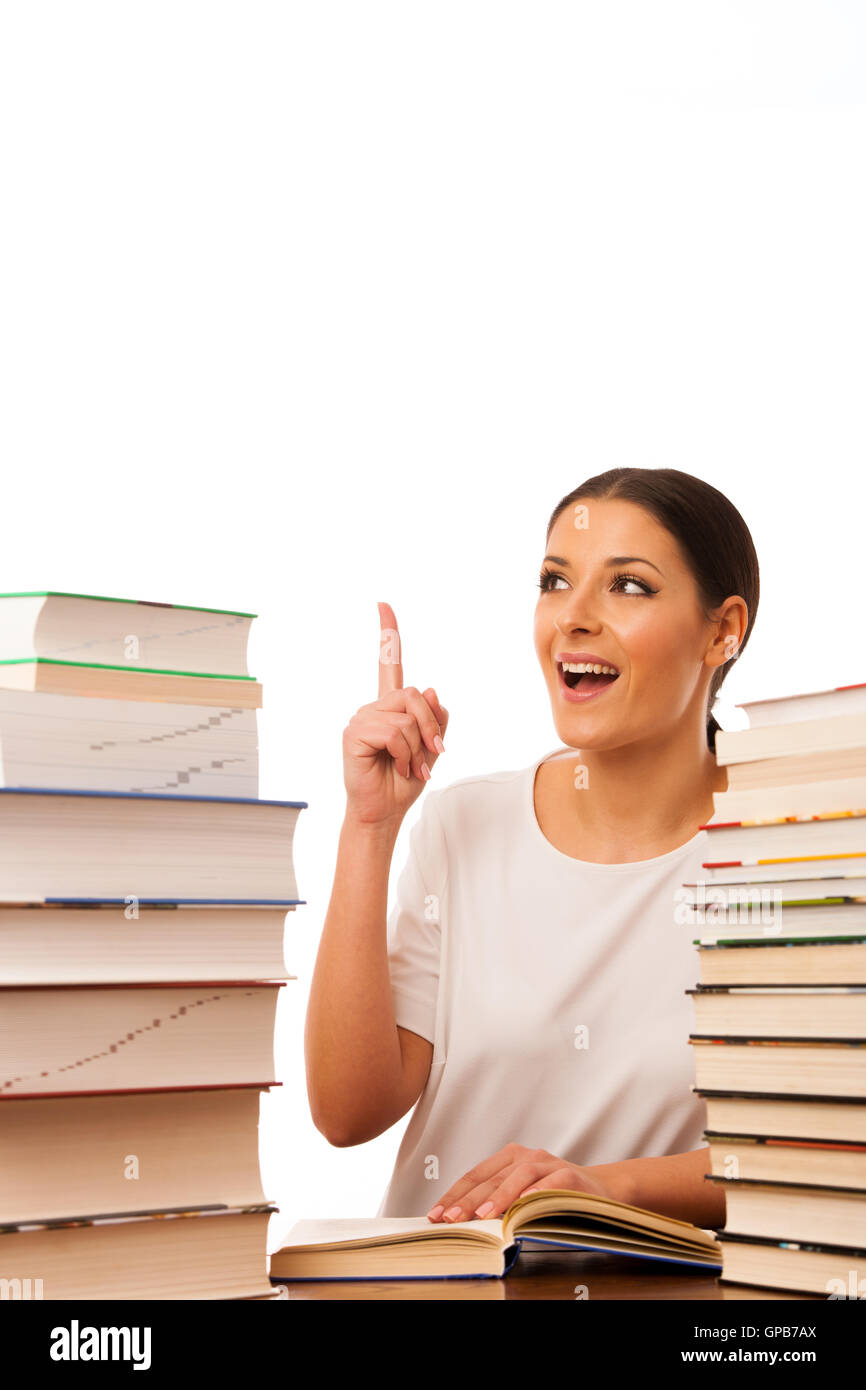 Excited woman reading behind the table between two pile of books Stock ...