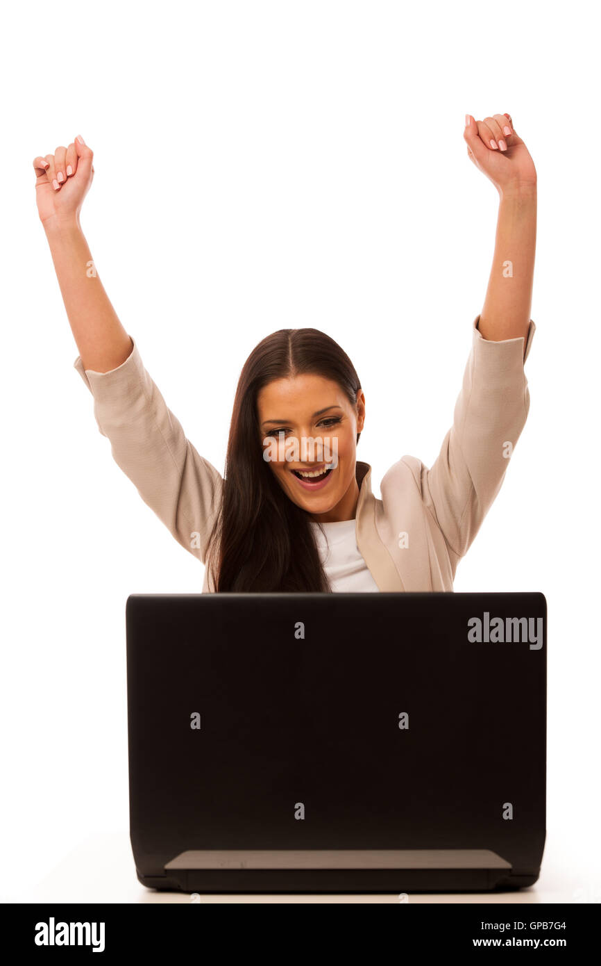 Excited woman looking into laptop computer with high raised hands happy ...