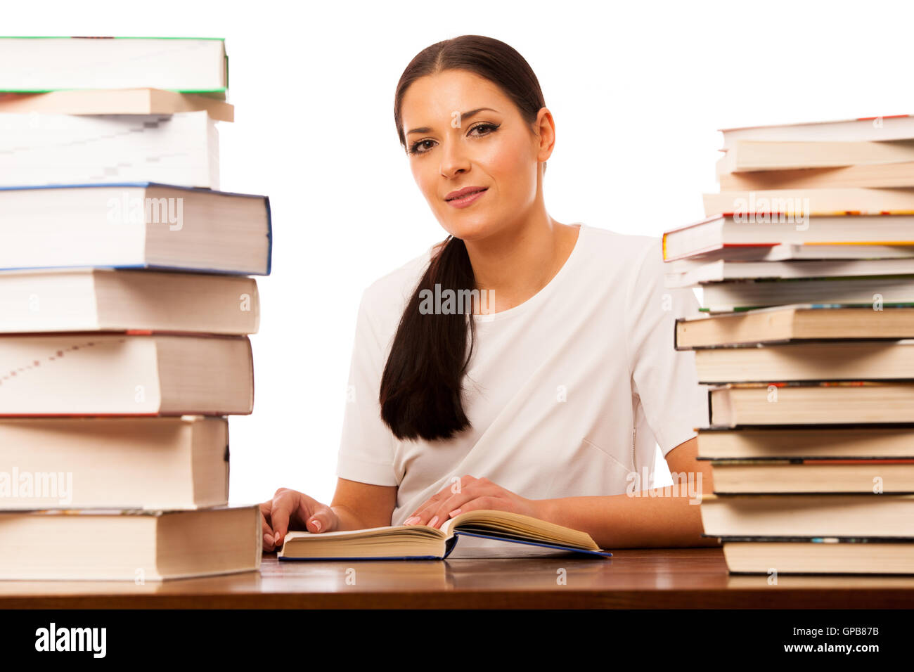Woman reading behind the table between two pile of books Stock Photo ...