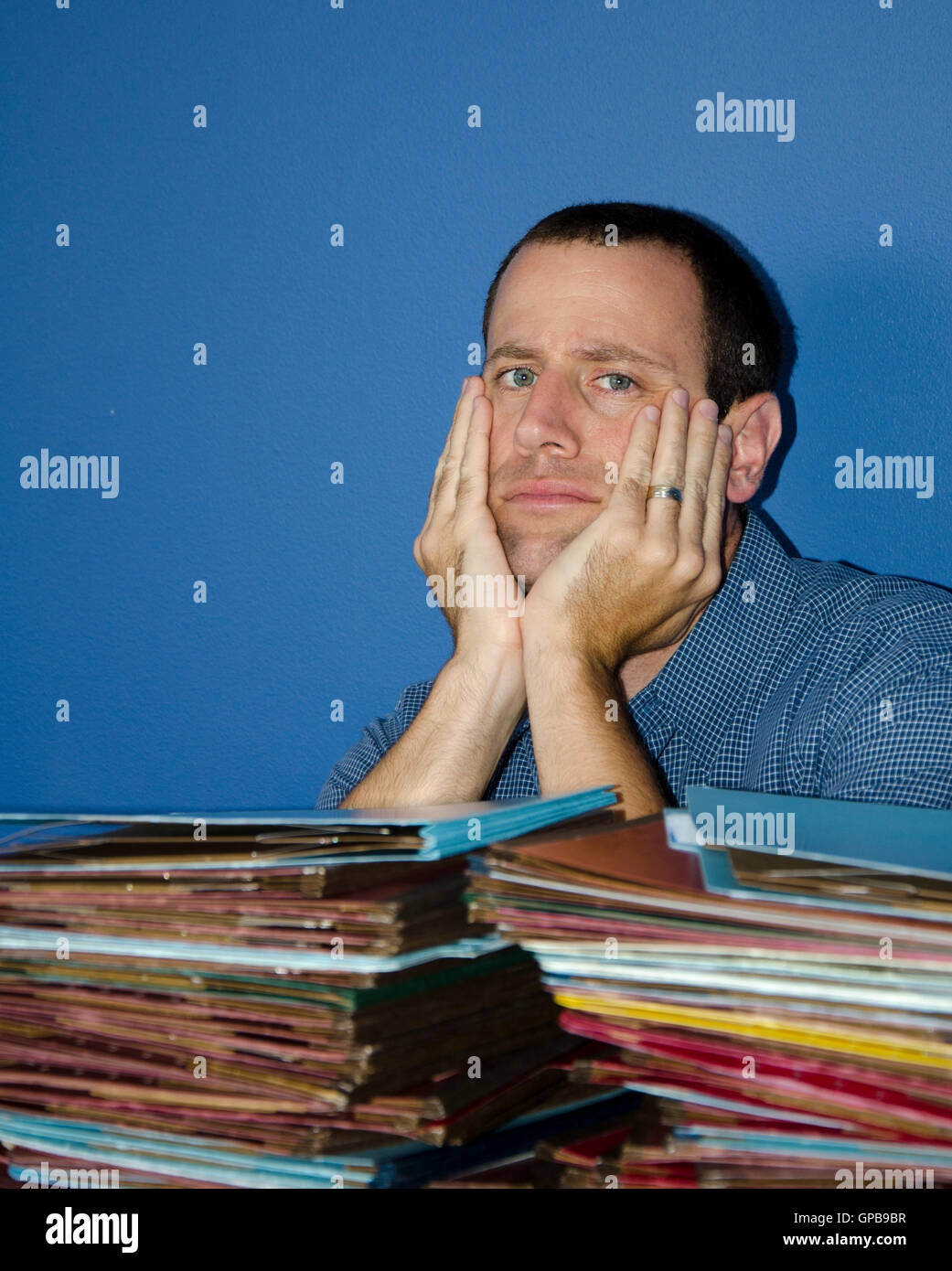 Young man at desk with hands on his cheeks stressed out by all the ...