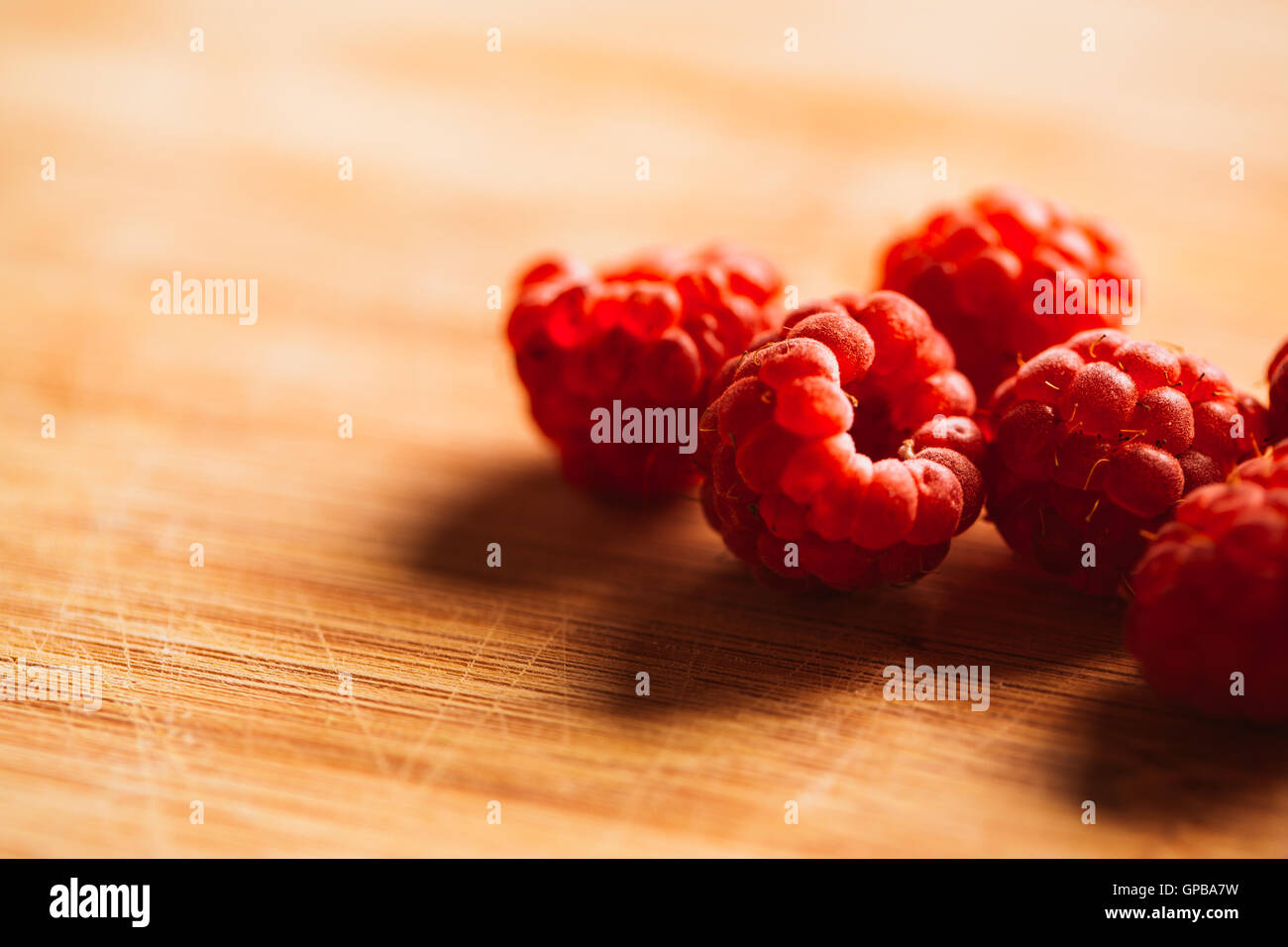 Raspberry on a blurred background of wooden planks Stock Photo - Alamy