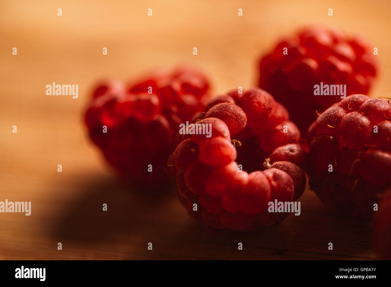 Raspberry on a blurred background of wooden planks Stock Photo - Alamy