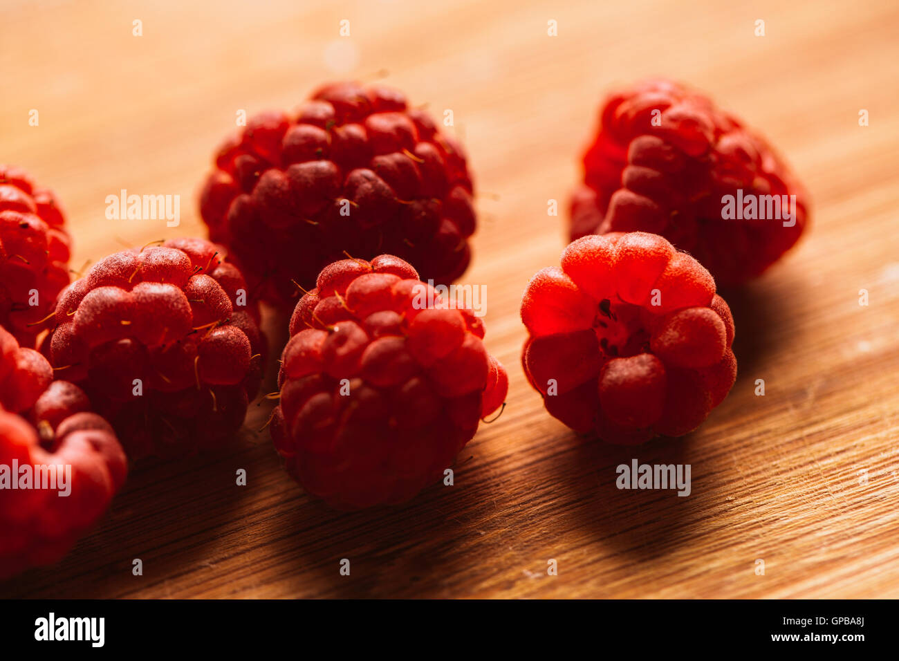 Raspberry on a blurred background of wooden planks Stock Photo - Alamy