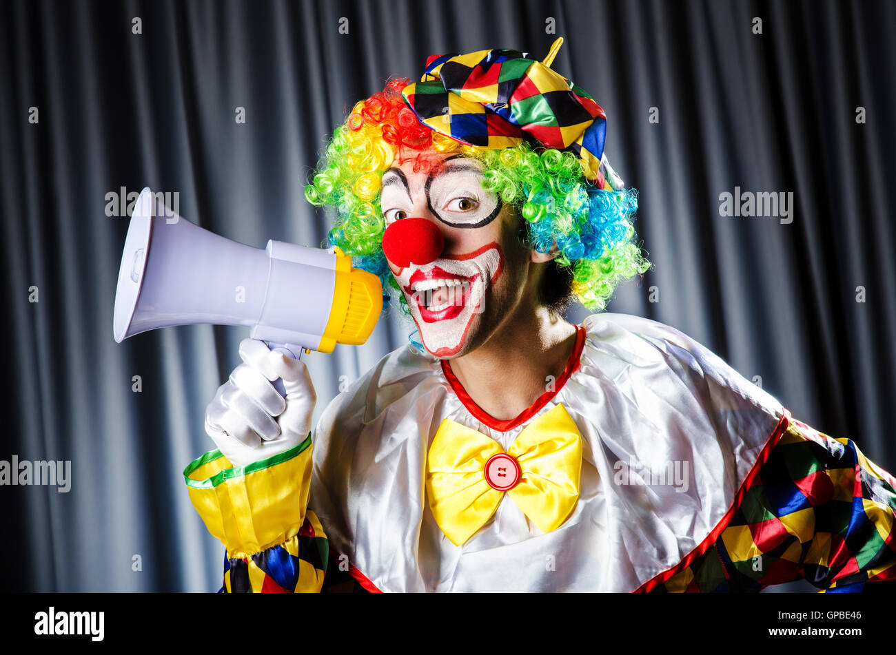 Clown in studio with loudspeaker Stock Photo - Alamy