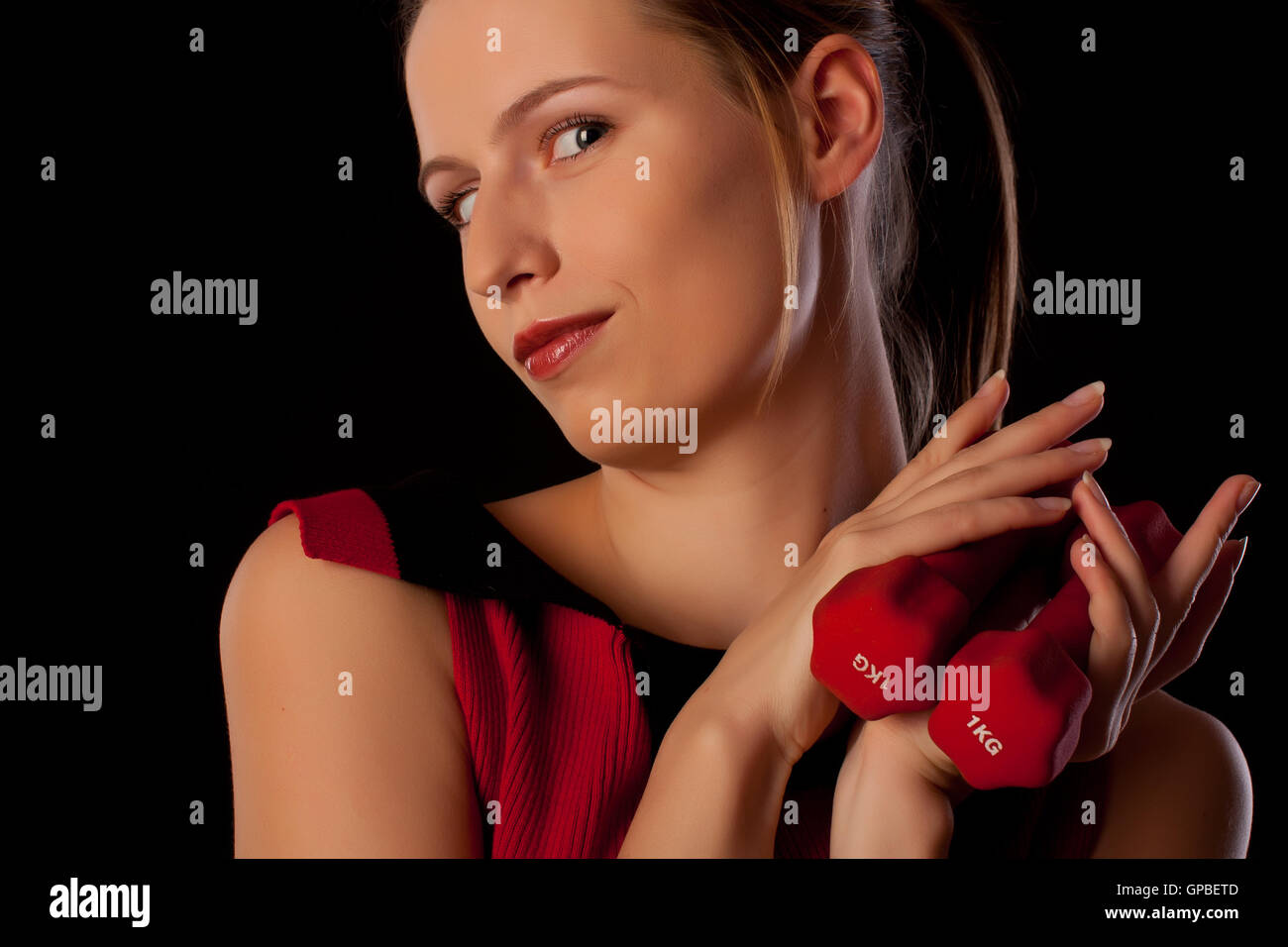Young woman playing with two dumbbells Stock Photo - Alamy