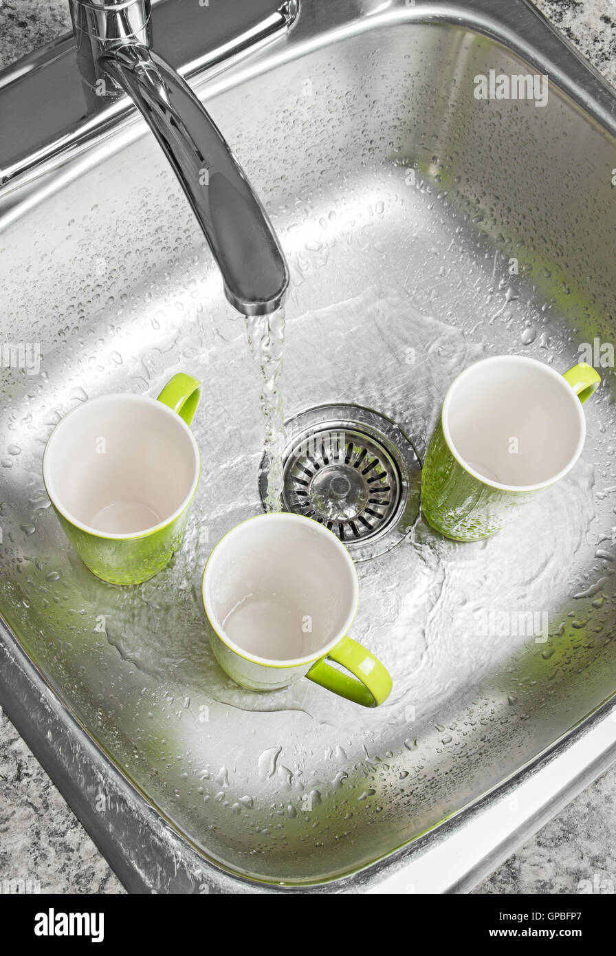 Washing cups in the kitchen sink Stock Photo - Alamy