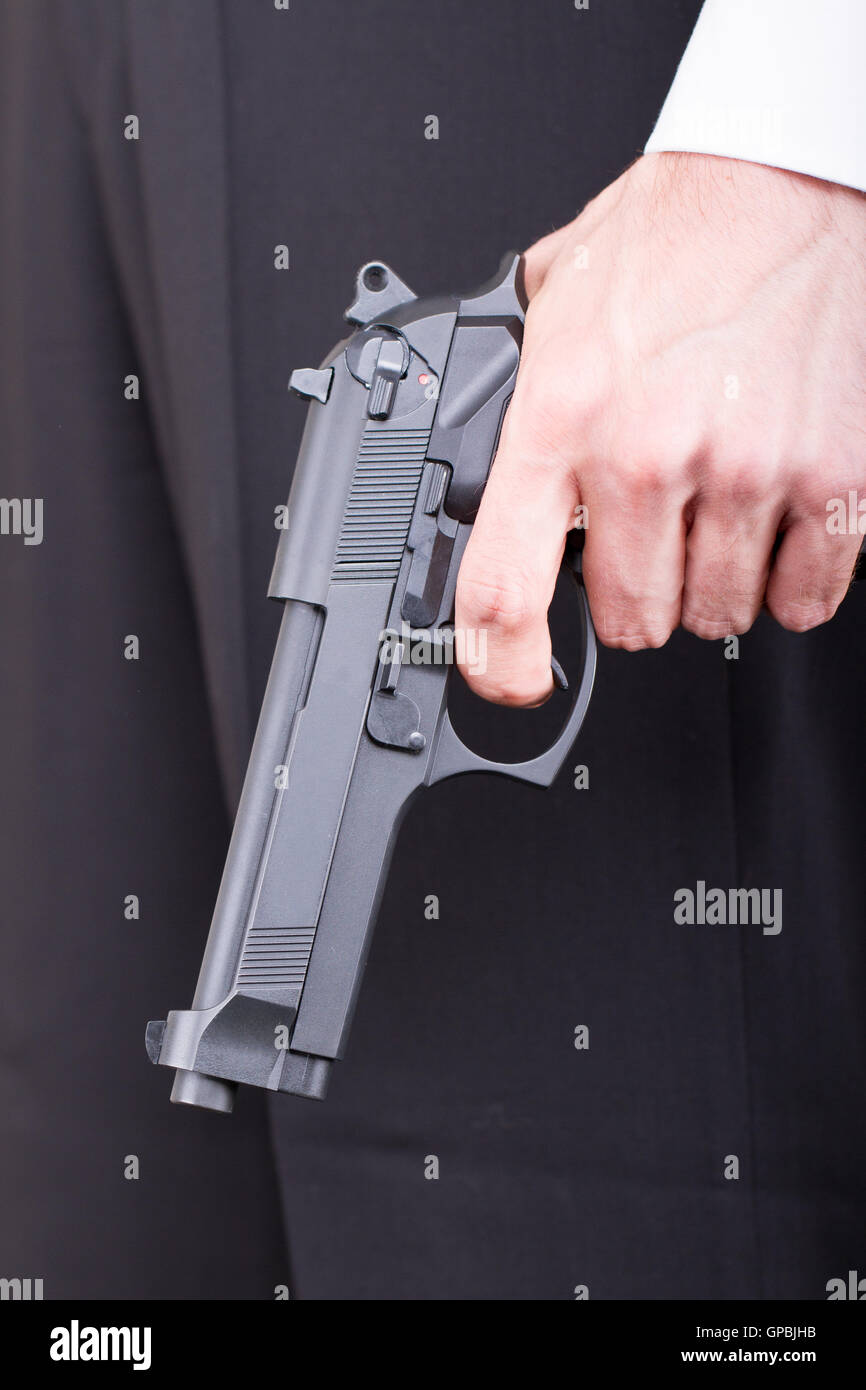 Man with gun, business suit, focus on the gun Stock Photo - Alamy