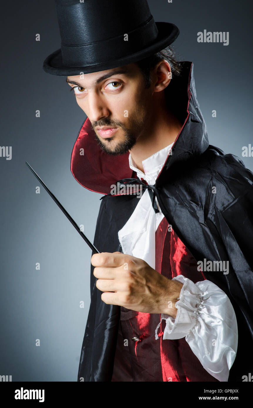 Magician doing tricks in dark room Stock Photo - Alamy