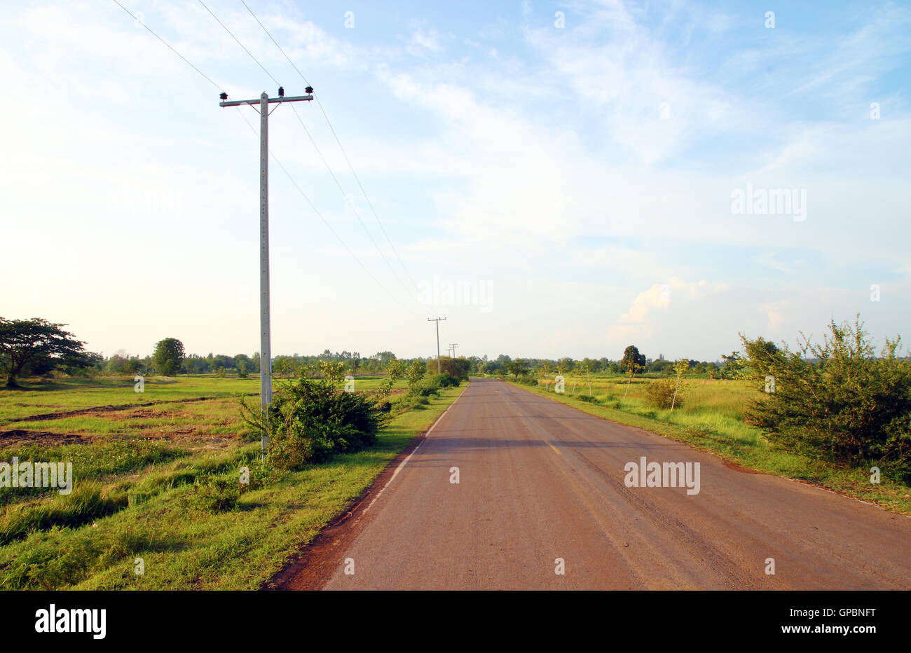 A country road running through green fields Stock Photo - Alamy