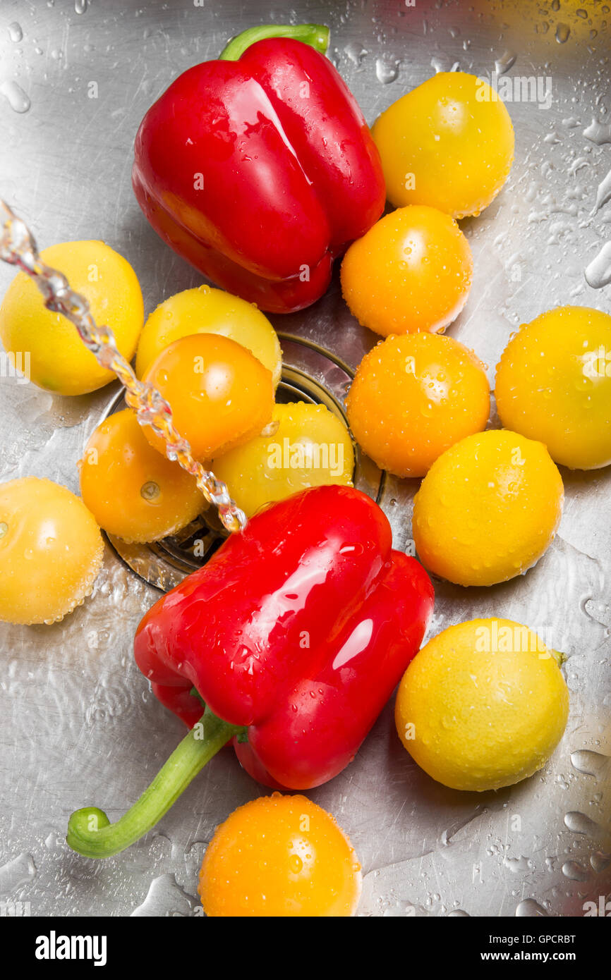 Washing red and yellow fruits and vegetables Stock Photo - Alamy