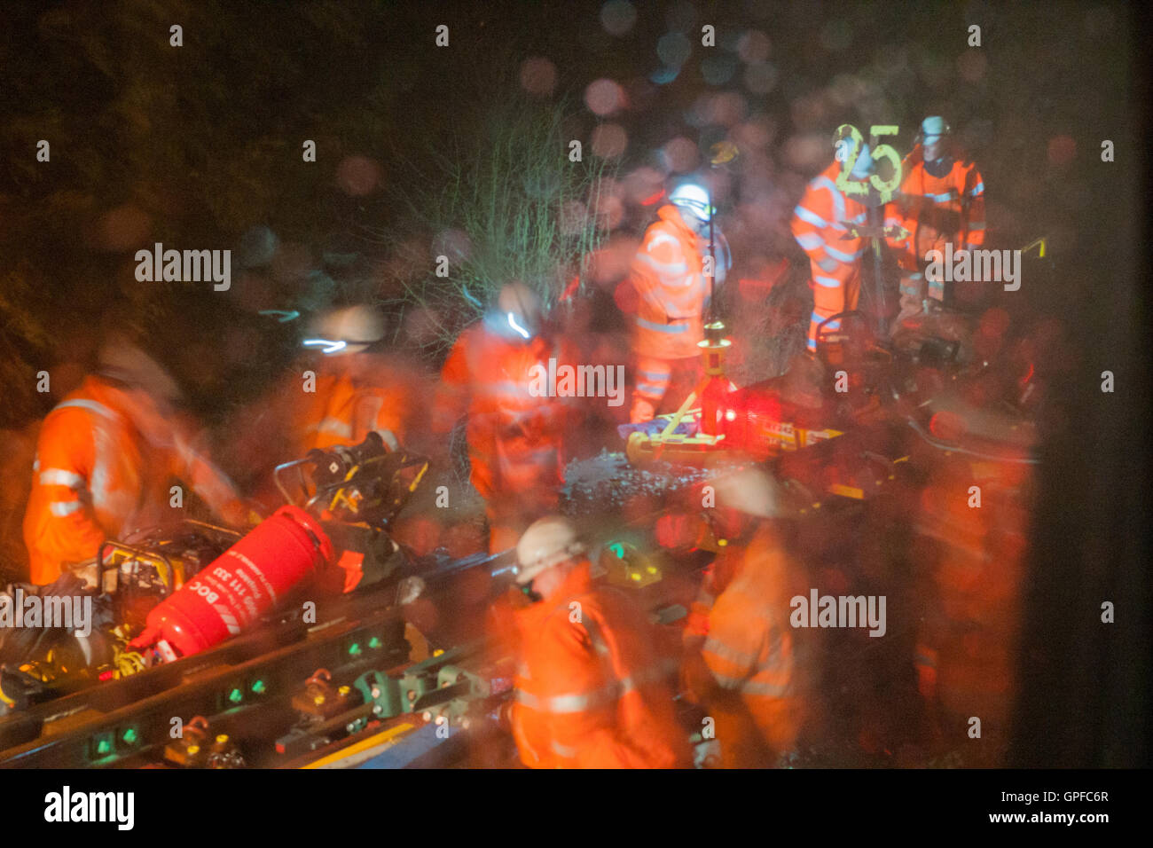 Railway track workers orange foul weather Stock Photo - Alamy