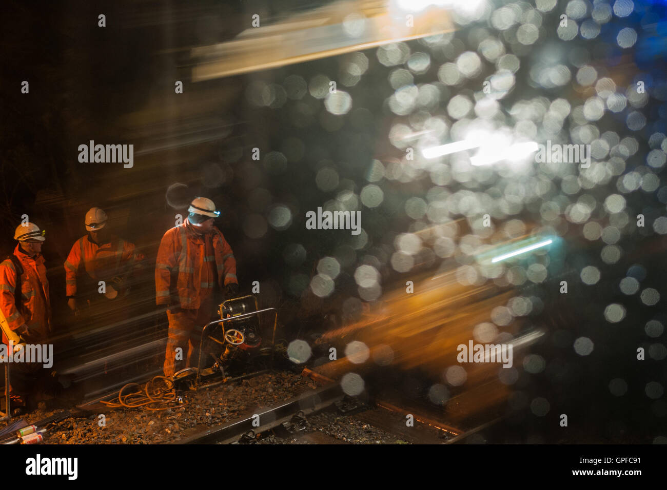 Railway track workers orange foul weather Stock Photo - Alamy