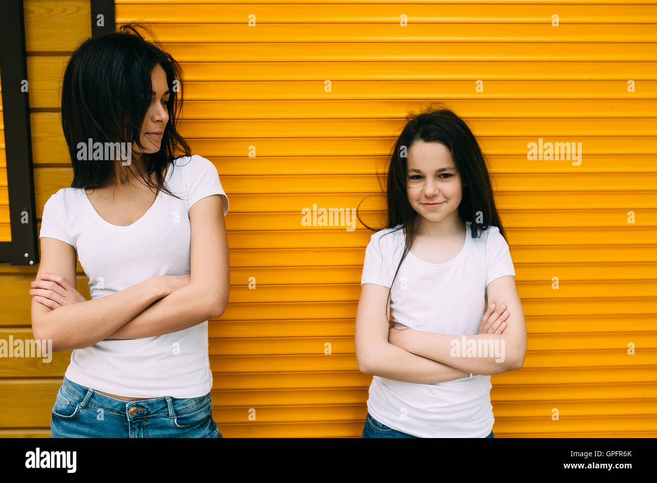 mother and her cute daughter, against wall Stock Photo - Alamy