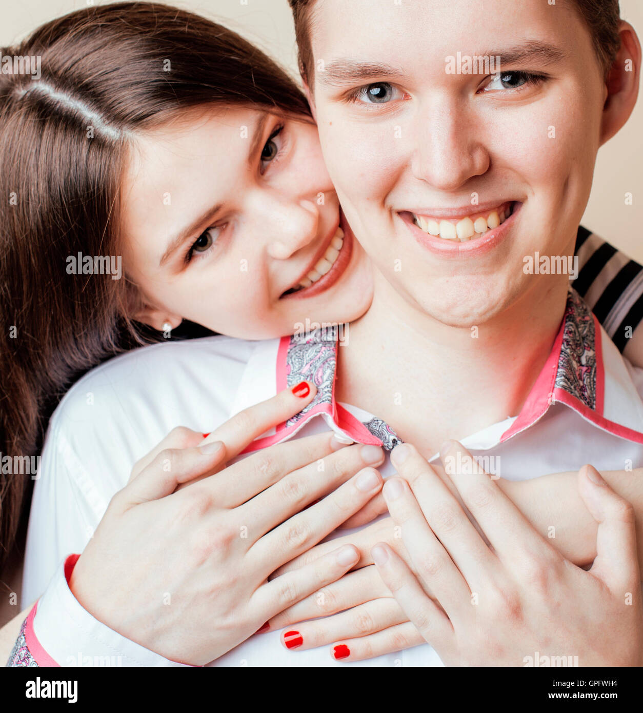 couple of happy smiling teenagers students, warm colors having a kiss ...