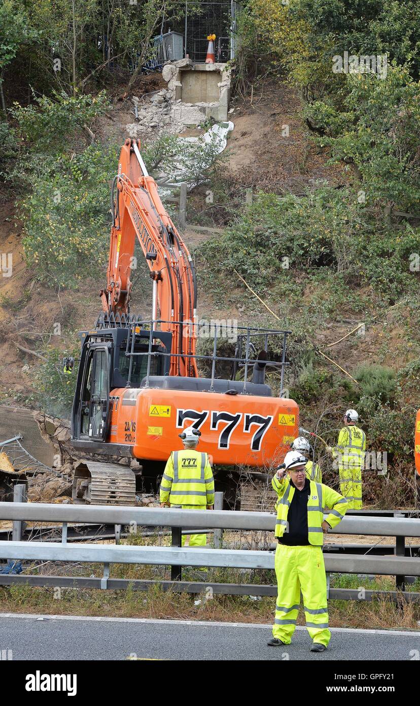 Demolition workers remove the remaining structure of a damaged ...