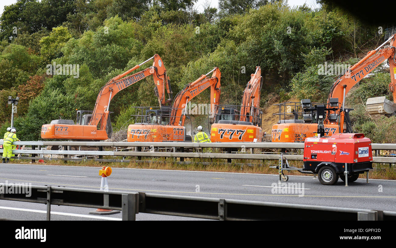 Demolition workers remove the remaining structure of a damaged ...