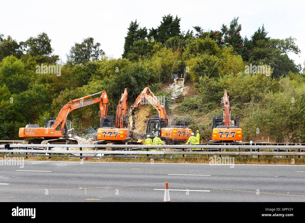 Demolition workers remove the remaining structure of a damaged ...