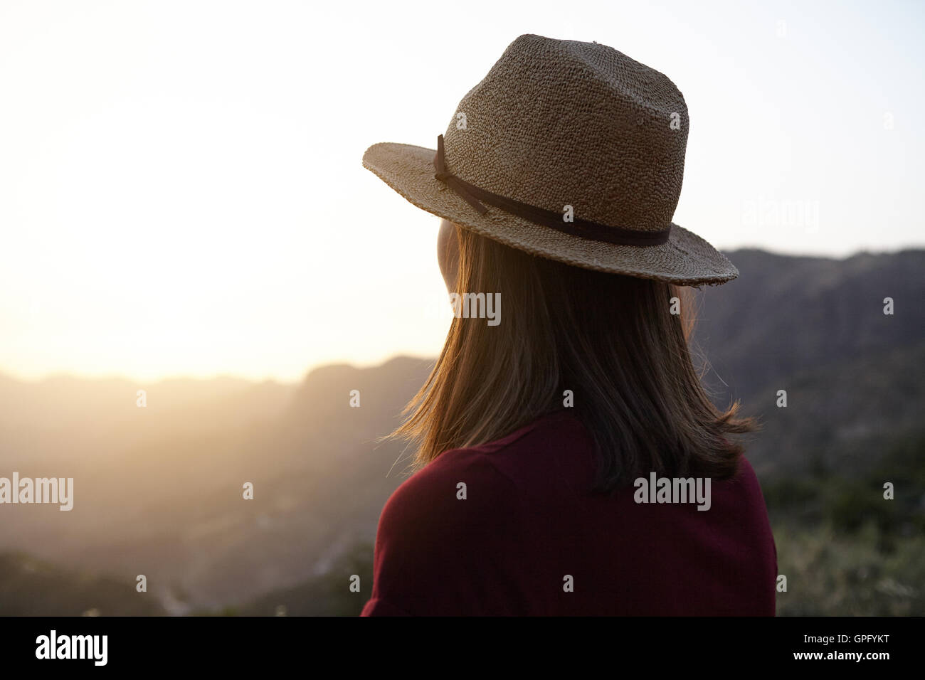 Girl from behind looking at something over the mountains in very bright ...