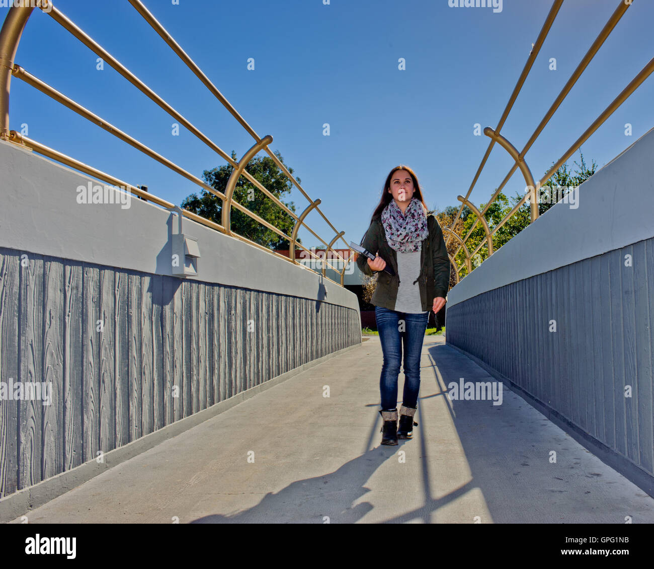 Female college student walking across walkway to class Stock Photo - Alamy