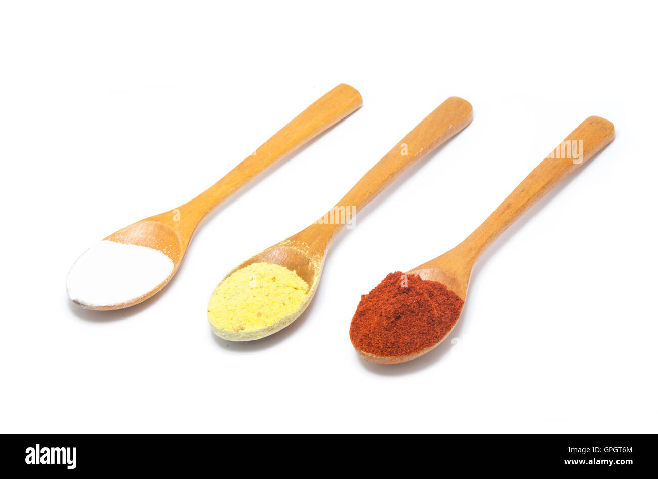 three common spices in wooden spoons isolated on white background Stock ...