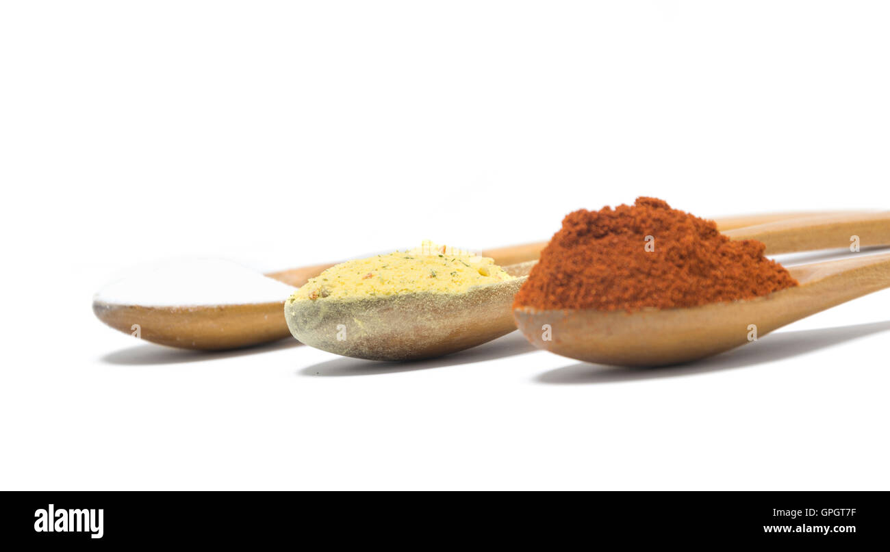three common spices in wooden spoons isolated on white background ...