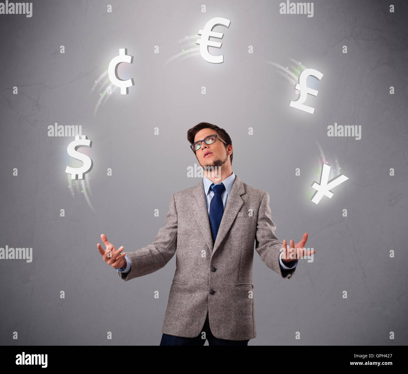 young man standing and juggling with currency icons Stock Photo - Alamy