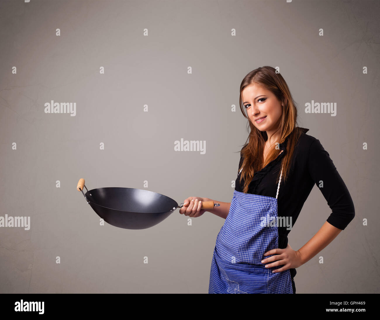 Young lady holding a frying pan Stock Photo - Alamy