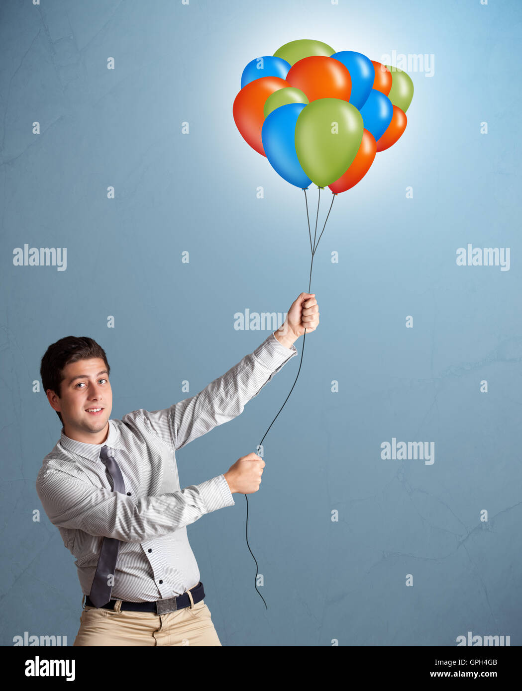Handsome man holding colorful balloons Stock Photo - Alamy