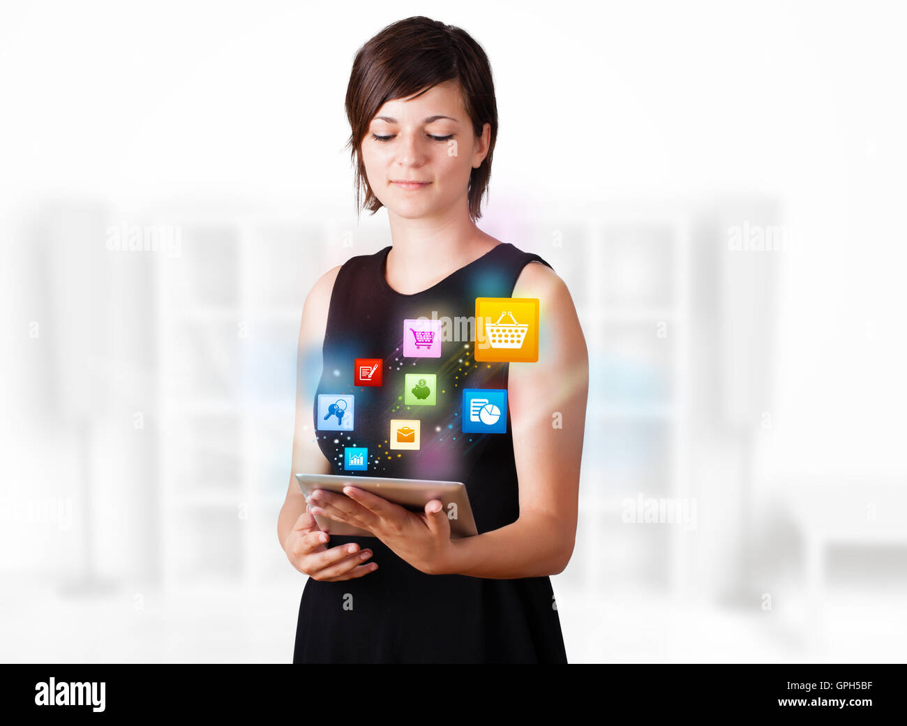 Young woman looking at modern tablet with colourful icons Stock Photo ...