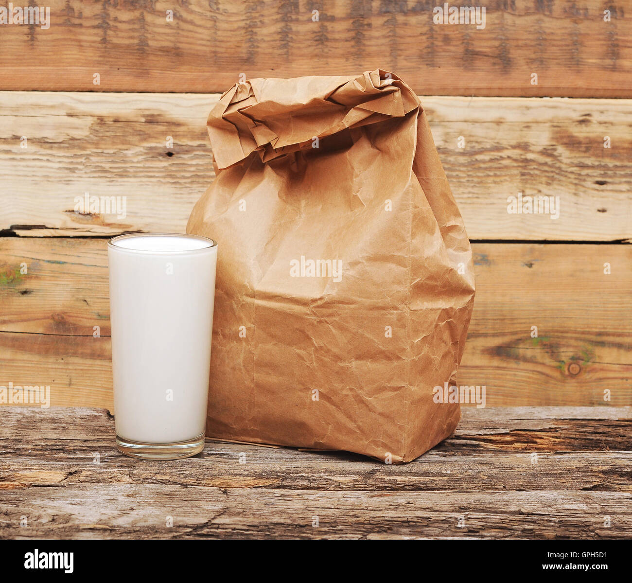 Paper lunch bags with glass milk over wooden background Stock Photo - Alamy