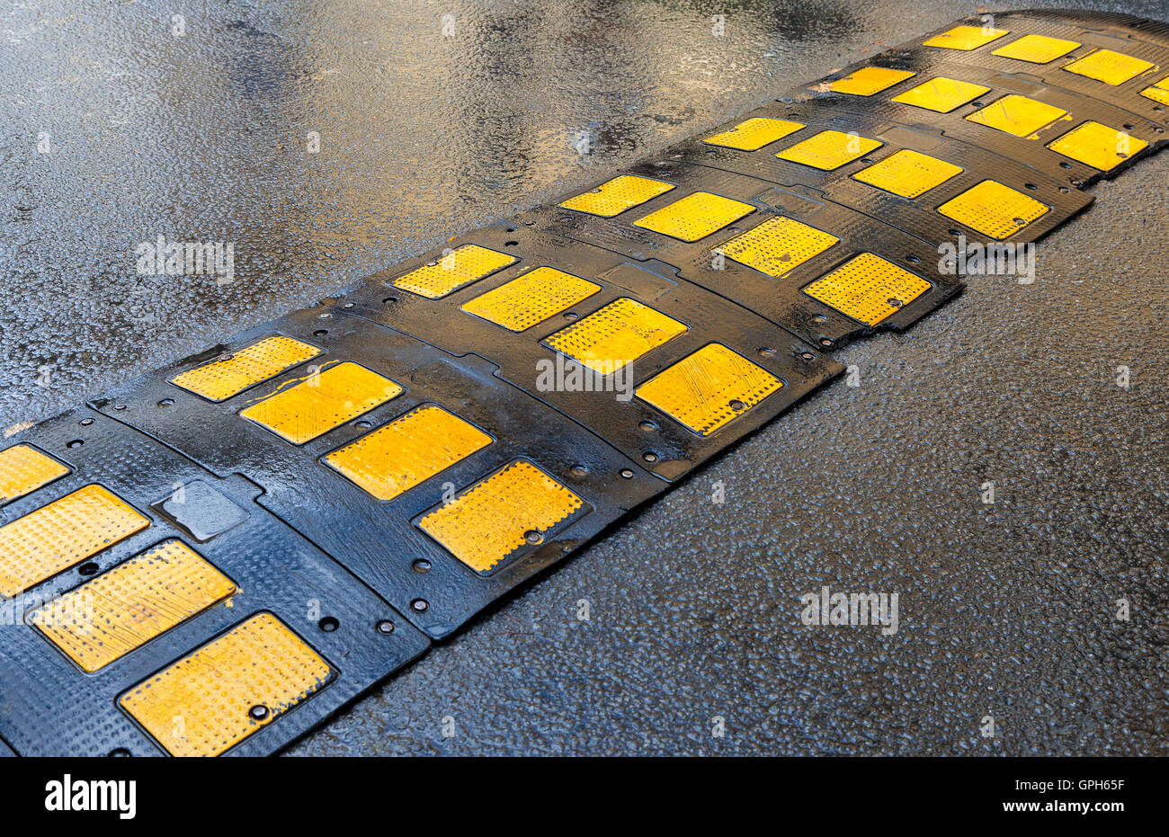 Traffic safety speed bump on an asphalt road Stock Photo - Alamy