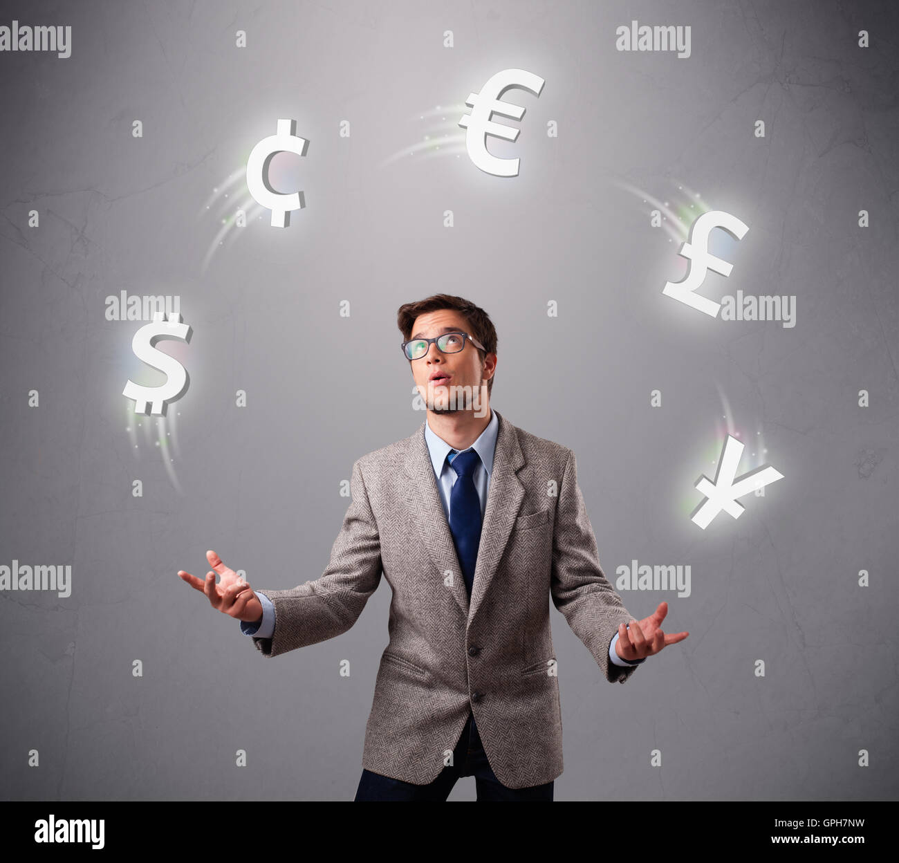 young man standing and juggling with currency icons Stock Photo - Alamy