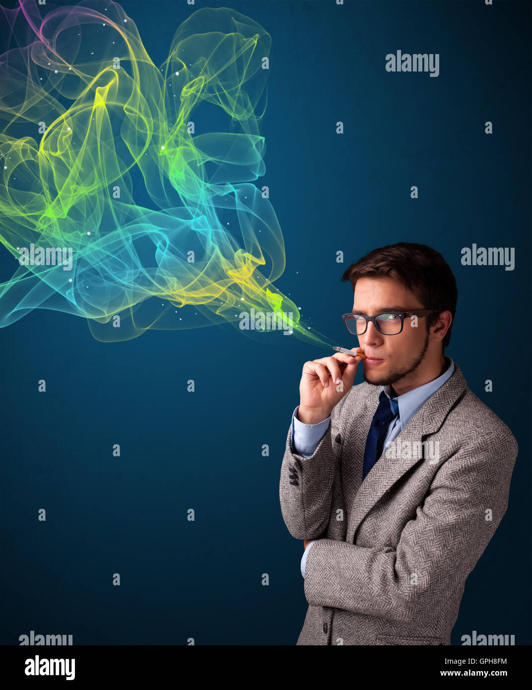 Handsome man smoking cigarette with colorful smoke Stock Photo - Alamy