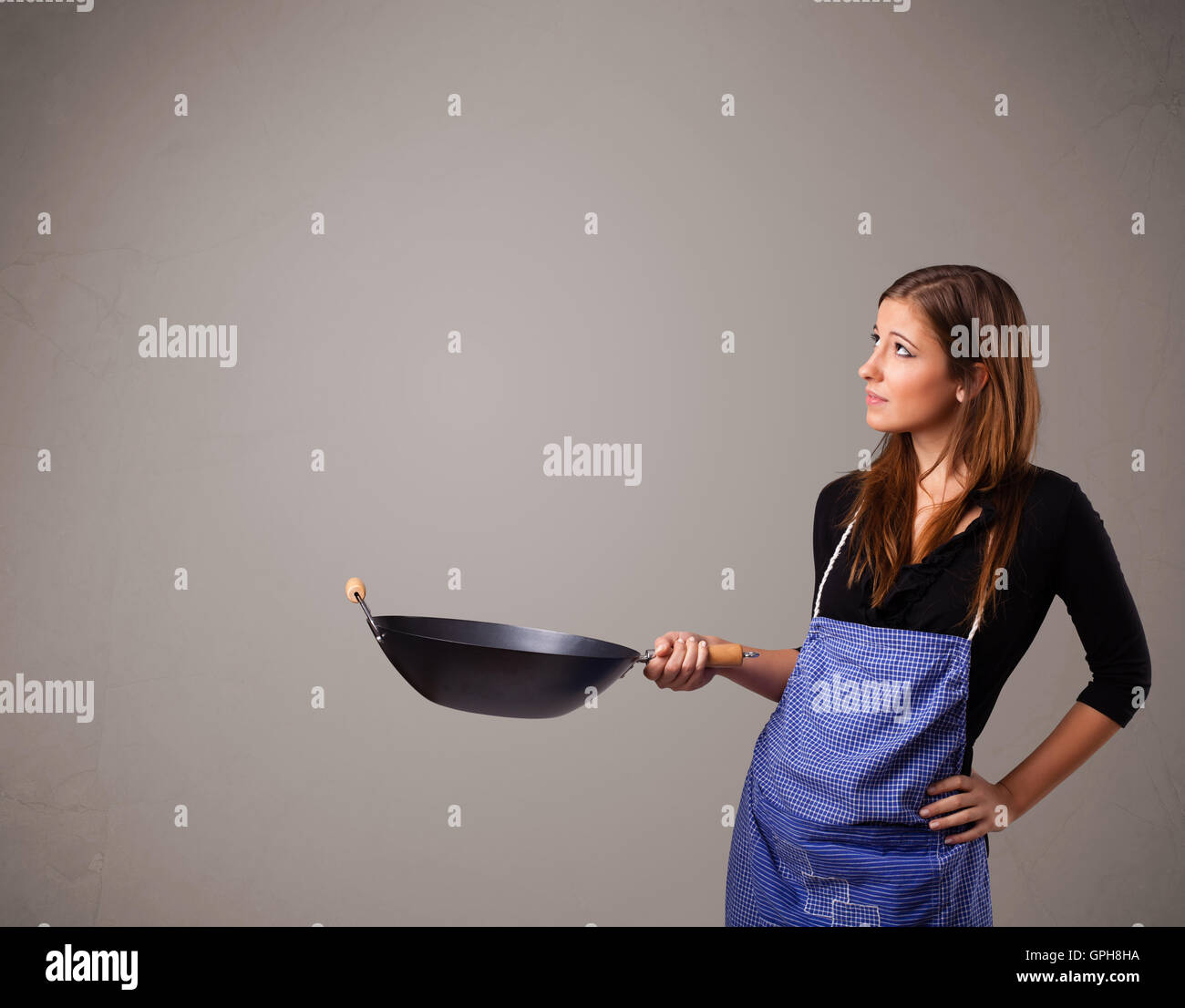 Young lady holding a frying pan Stock Photo - Alamy