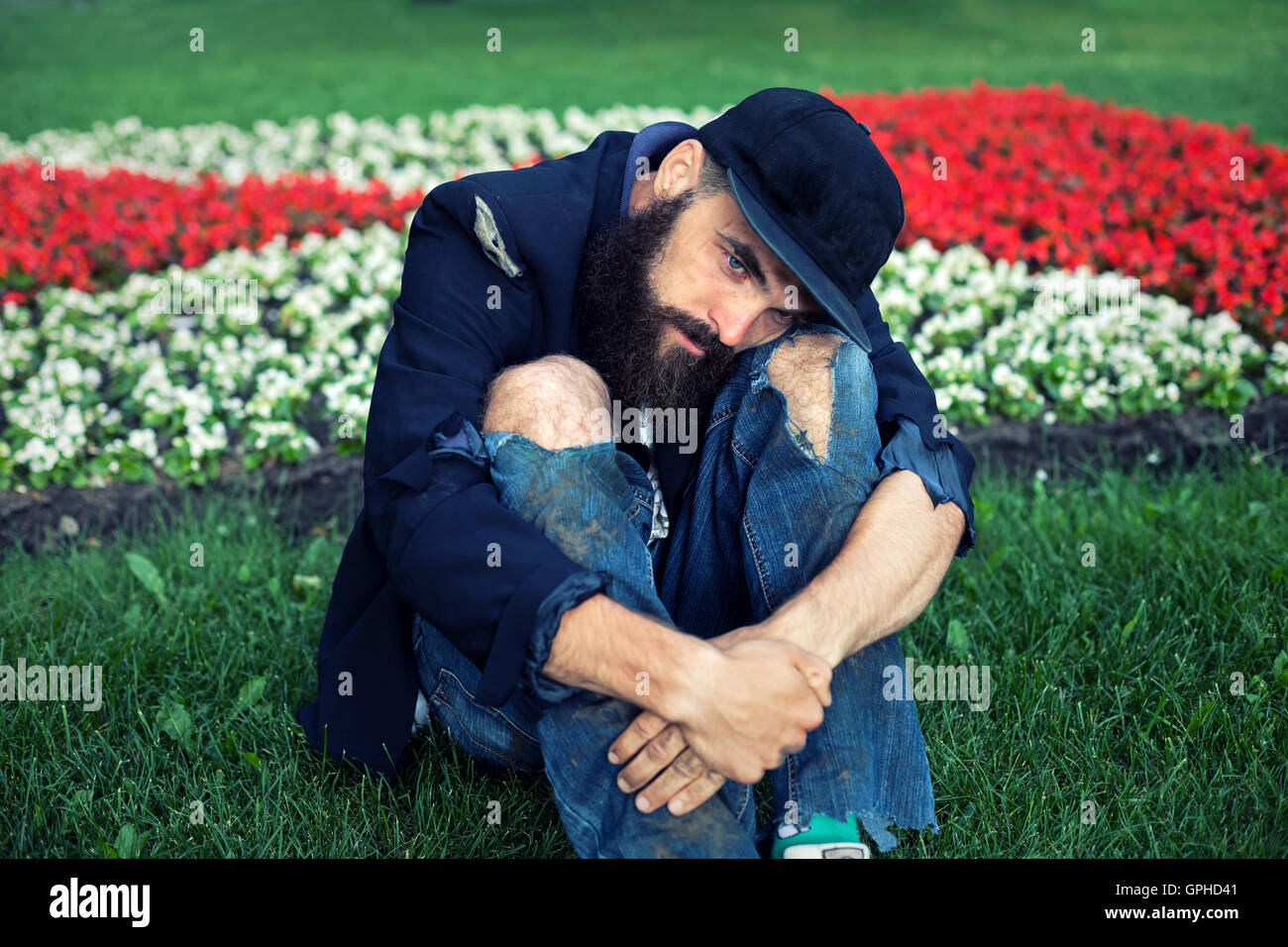 Vagrant in flowerbed Stock Photo - Alamy