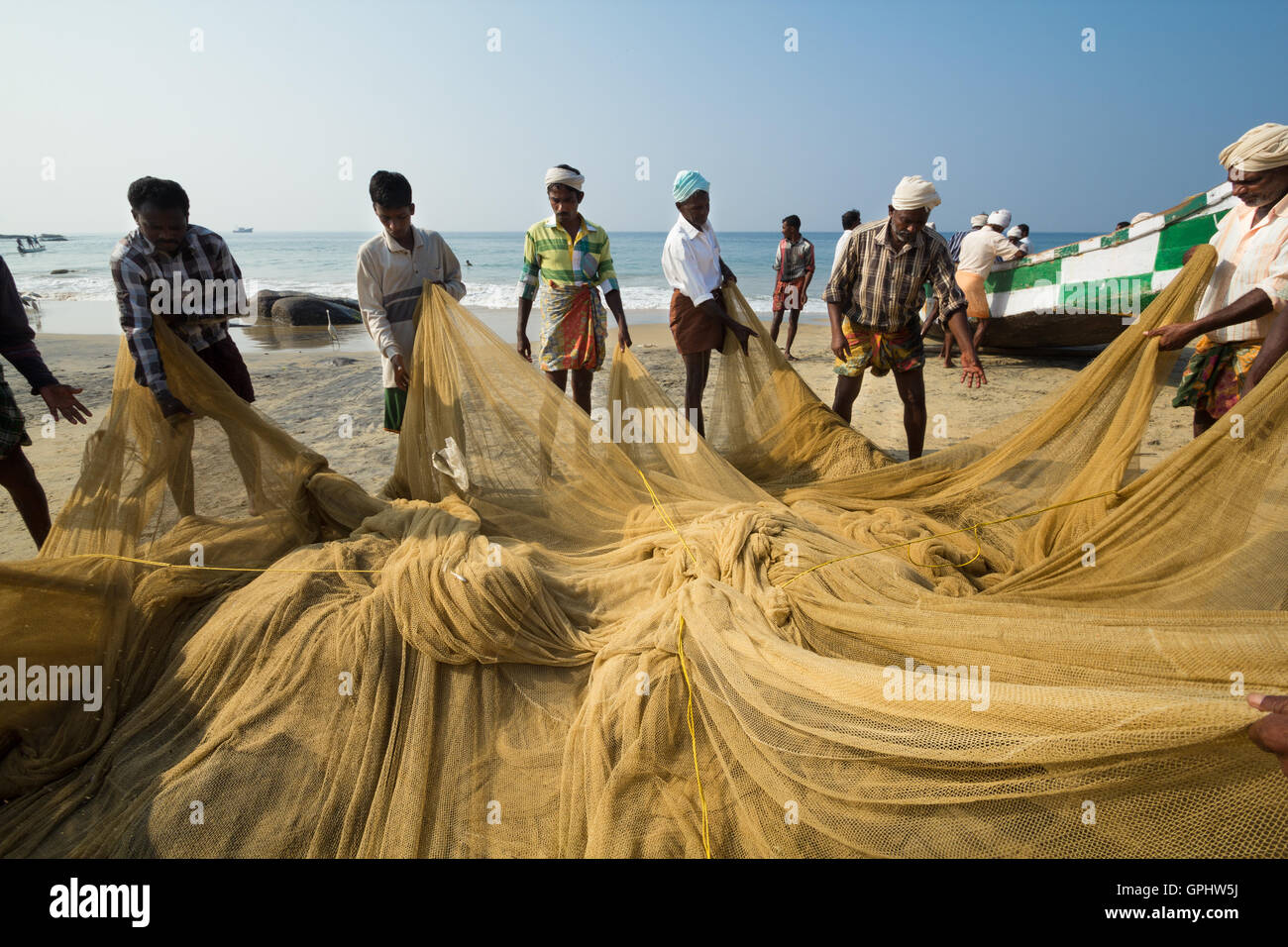 Fishermen repairing their huge nets for catching fishes the traditional ...