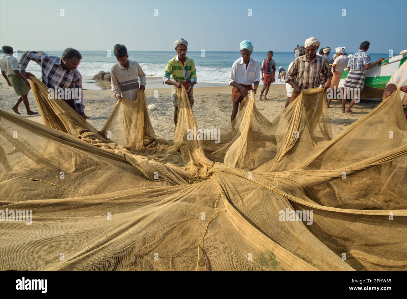 Fishermen repairing their huge nets for catching fishes the traditional ...