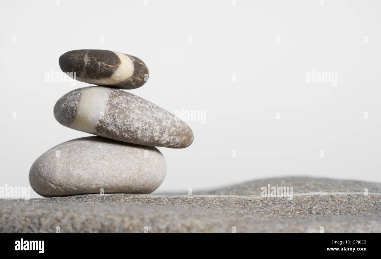 stacked rounded stone pebble arrangement in light grey back Stock Photo ...