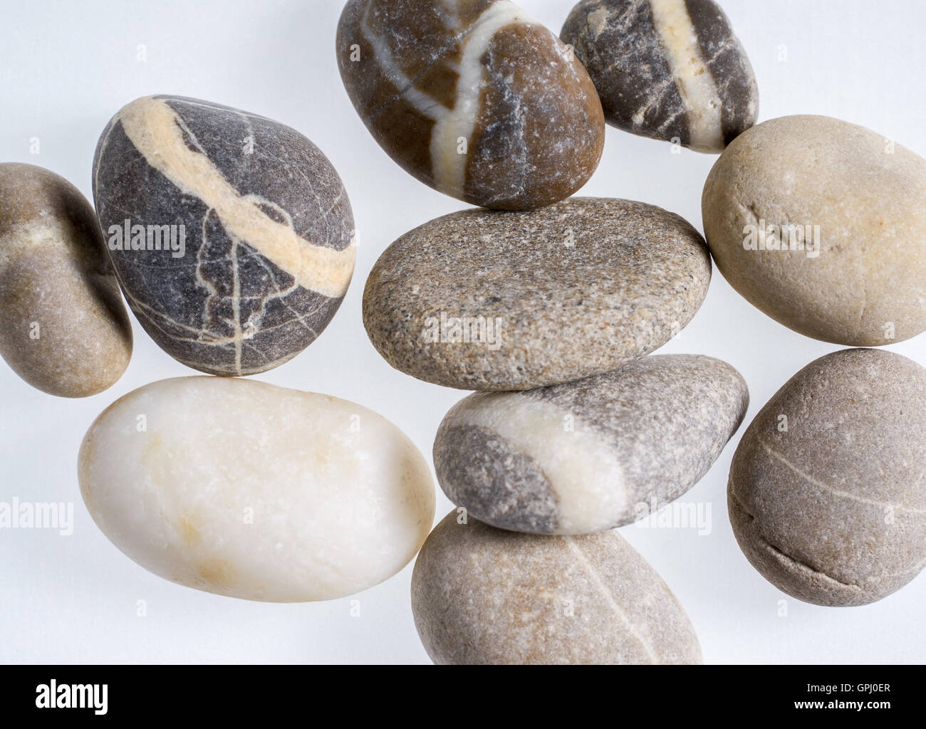 rounded stone pebble arrangement in light grey back Stock Photo - Alamy