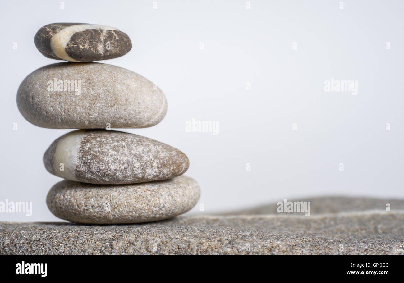 stacked rounded stone pebble arrangement in light grey back Stock Photo ...