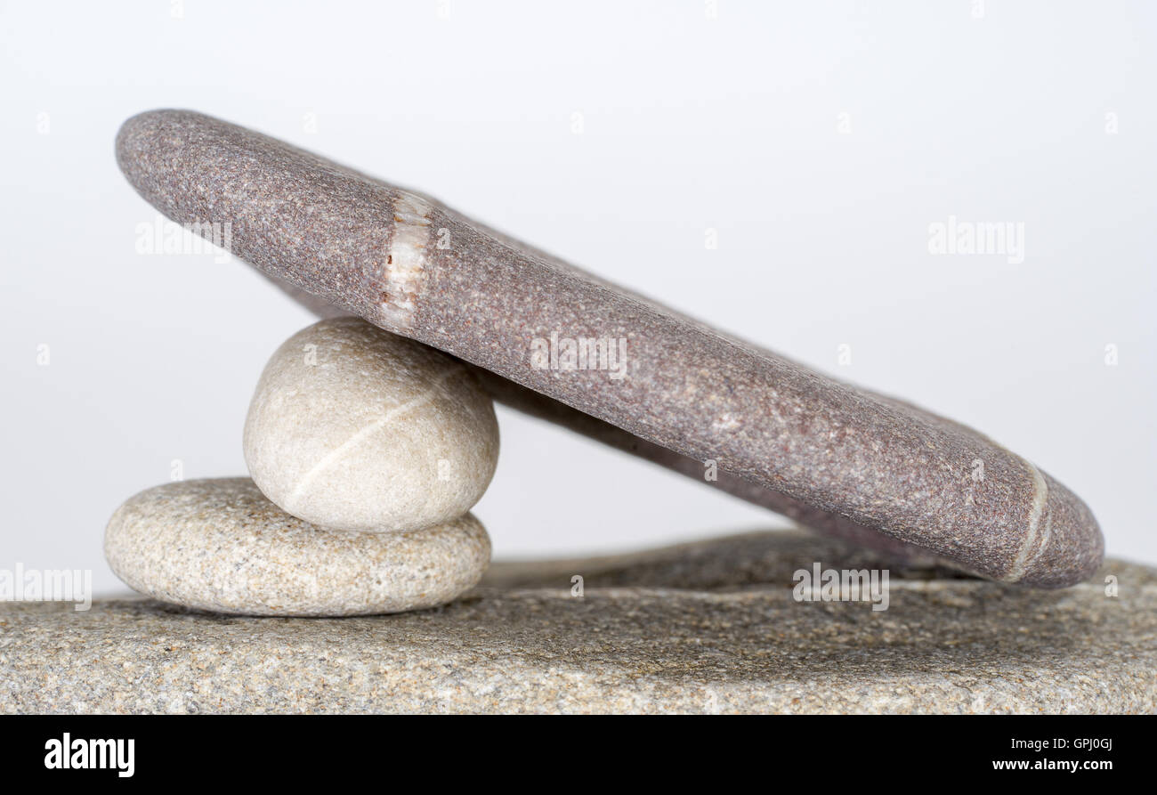 stacked rounded stone pebble arrangement in light grey back Stock Photo ...