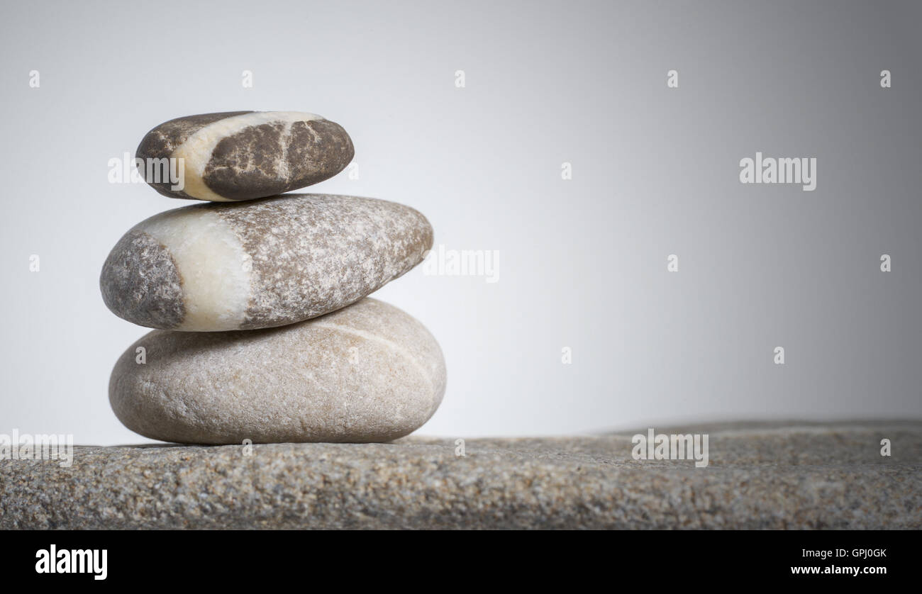 stacked rounded stone pebble arrangement in grey back Stock Photo - Alamy