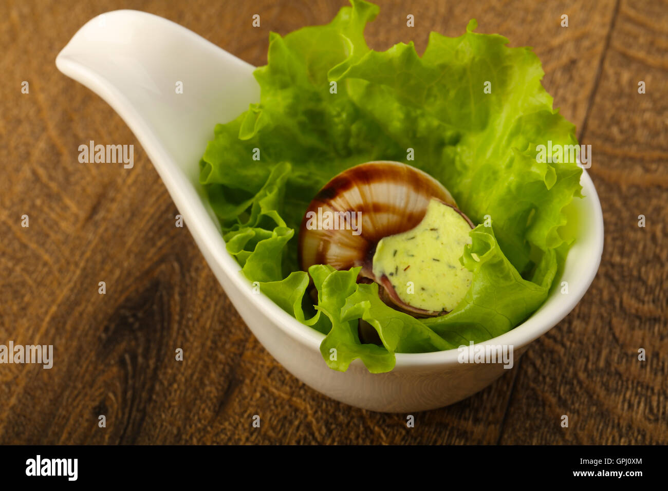 Escargot with cheese cream on salad leaves Stock Photo - Alamy