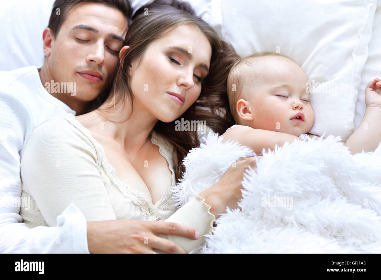 Sleeping family and child in bed Stock Photo - Alamy