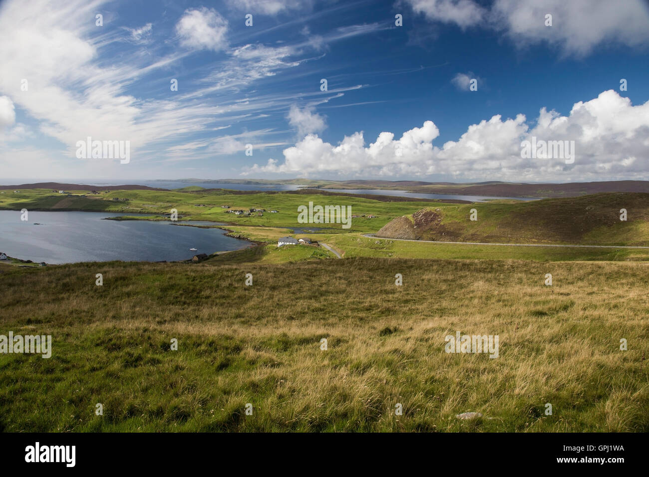 A view of Whiteness Voe in Shetland with blue sky and wispy clouds in ...
