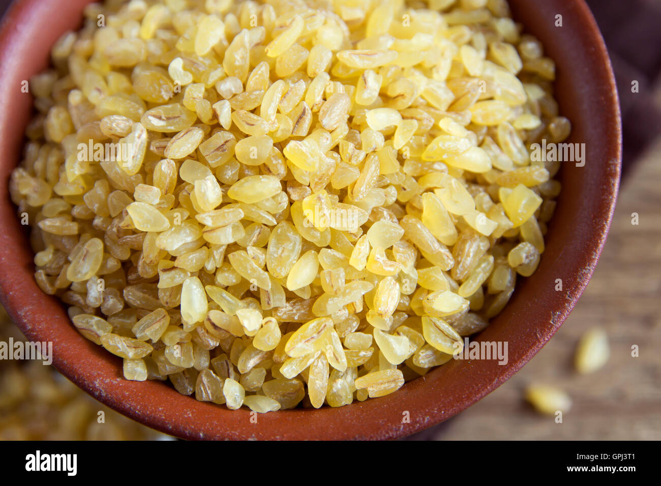 Organic bulgur raw wheat grain in ceramic bowl close up Stock Photo - Alamy