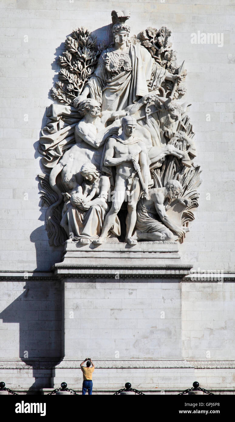 A tourist photographs La Paix de 1815 on the Arce de Triomphe, Paris ...