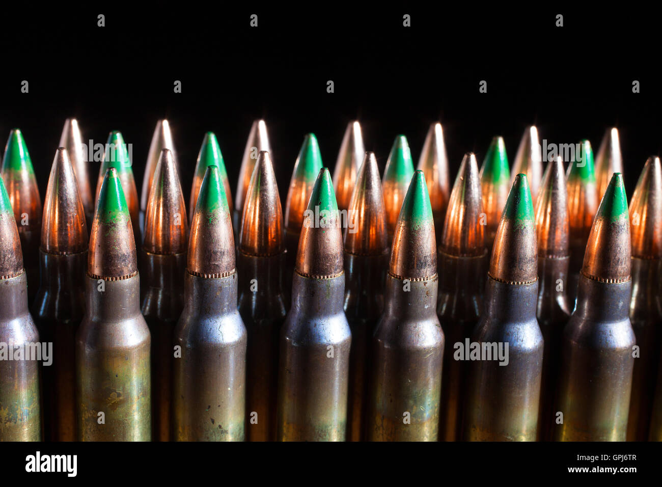Three rows of cartridges with some having green tipped bullets Stock ...