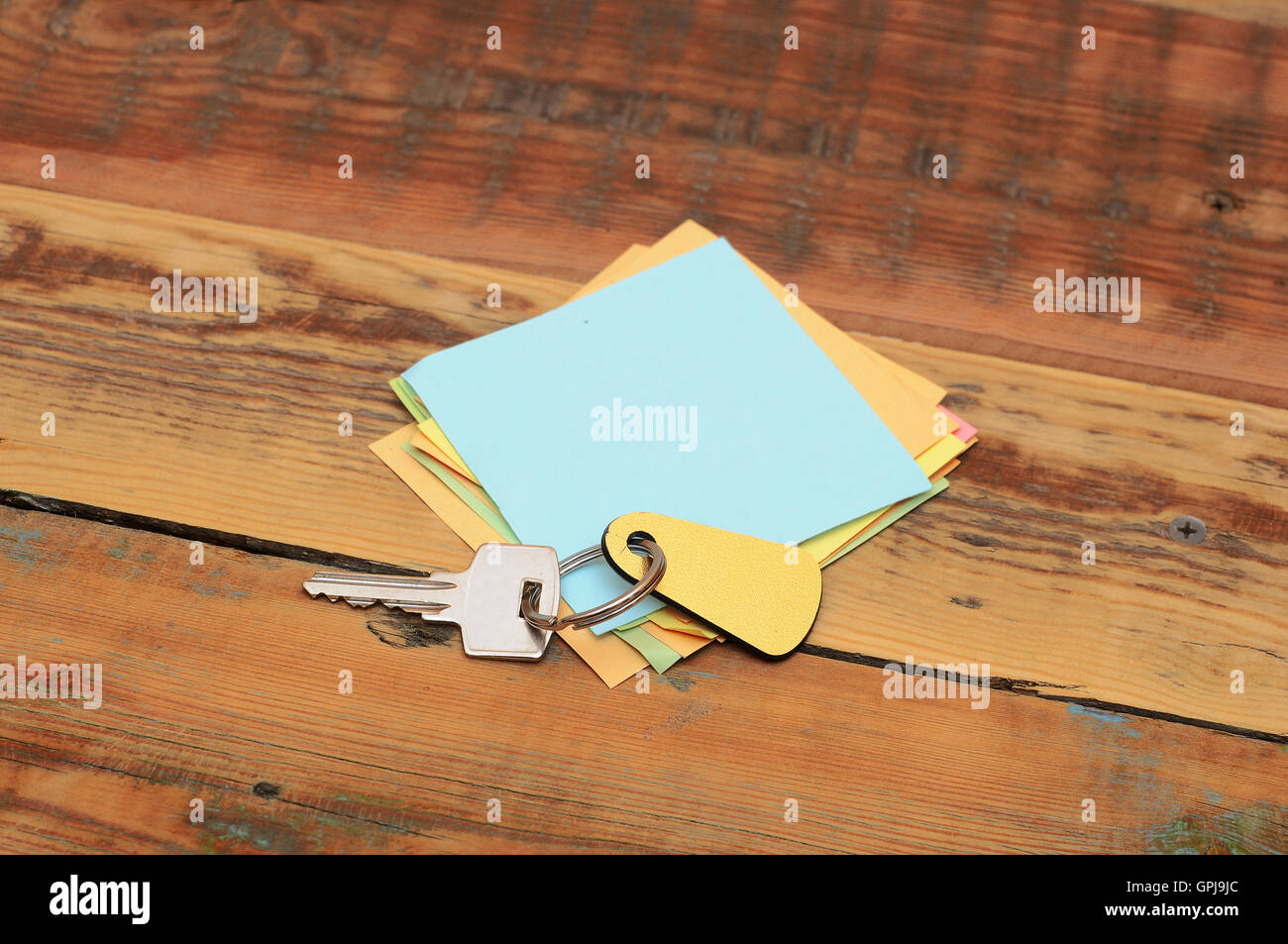 clean post-it note on a wood background with a key Stock Photo - Alamy