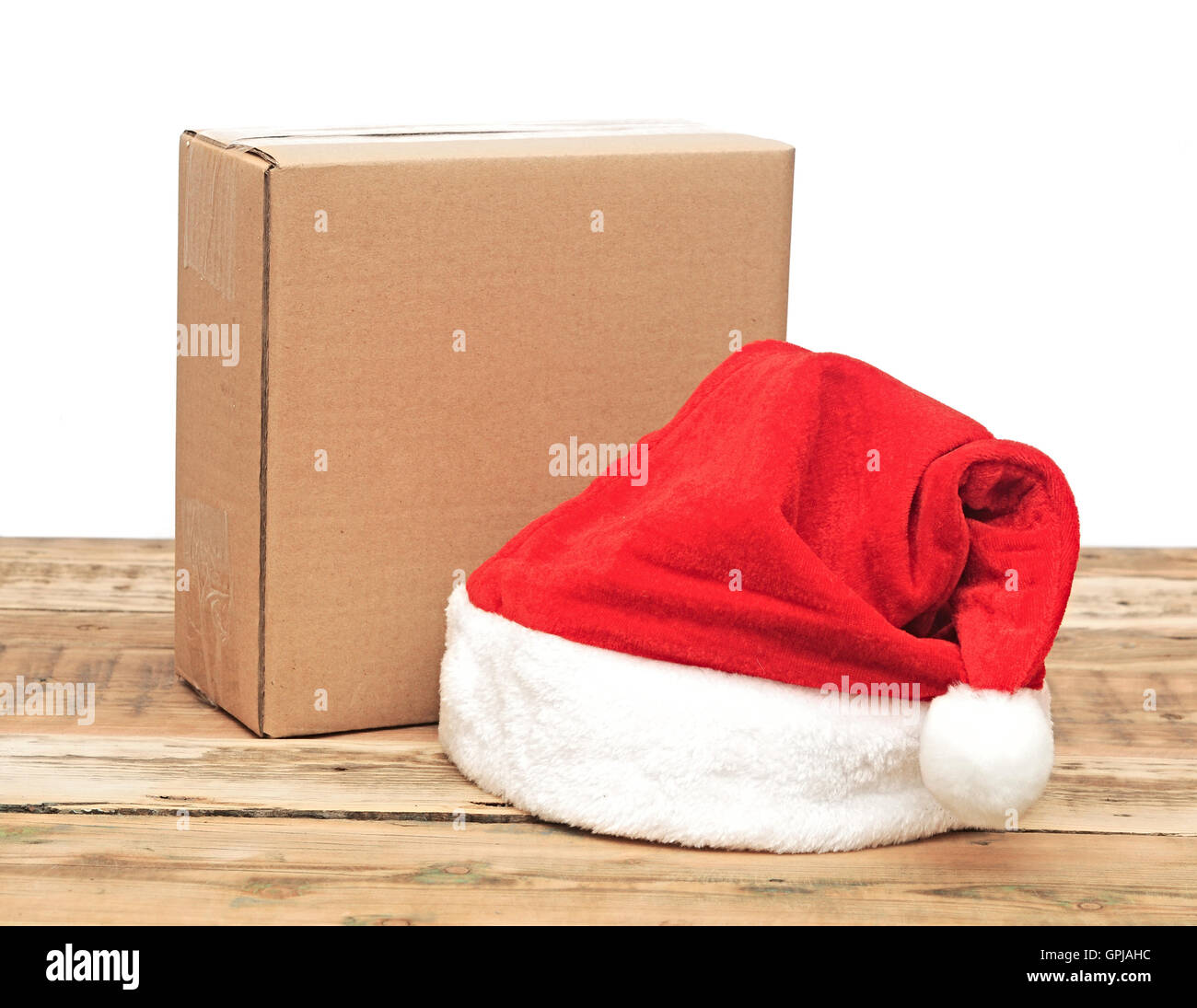 santa hat with brown cardboard box over white Stock Photo - Alamy